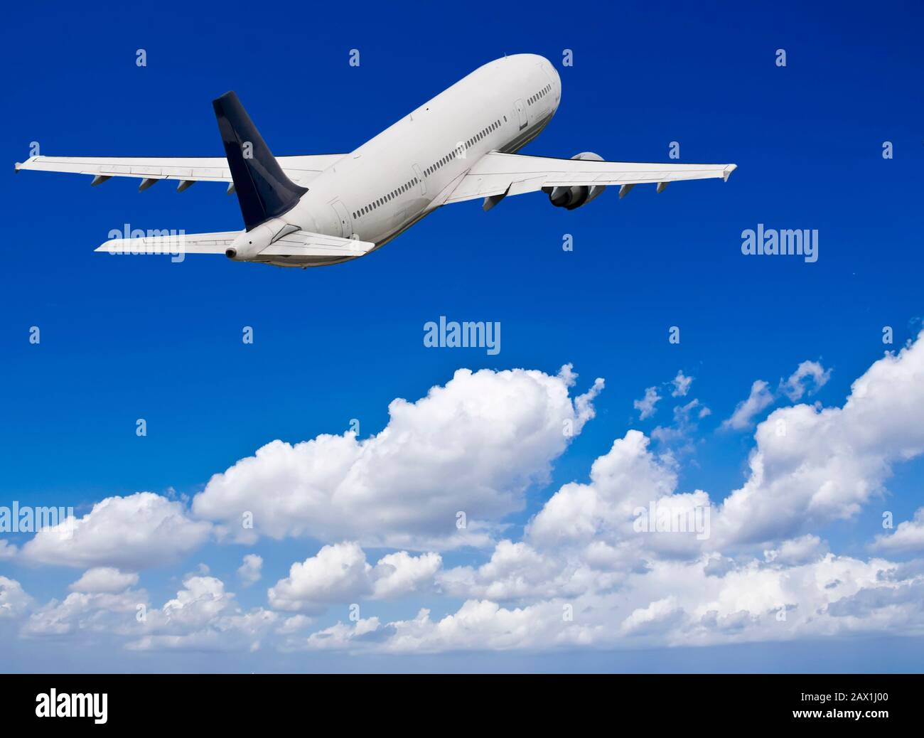 Civil aircraft flying into deep blue skies with some cloud Stock Photo ...