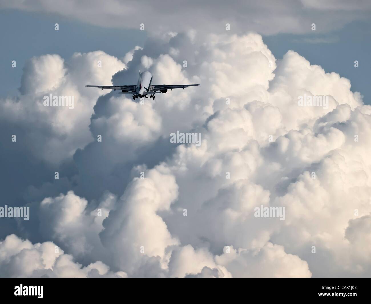 Civil aircraft climbing into large nimbus cloud Stock Photo - Alamy