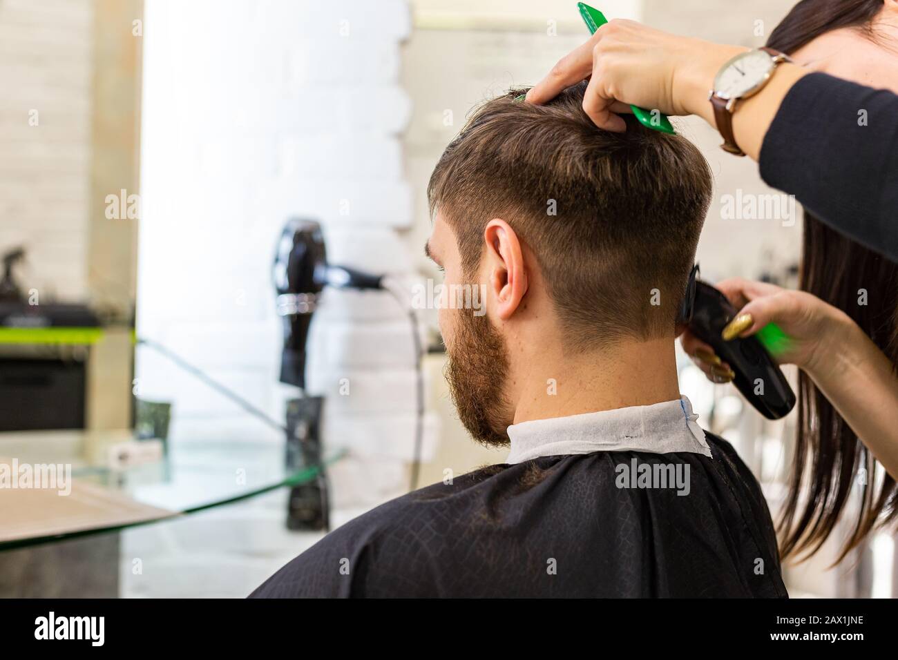 Hairdresser doing haircut for male client, man with beard using ...