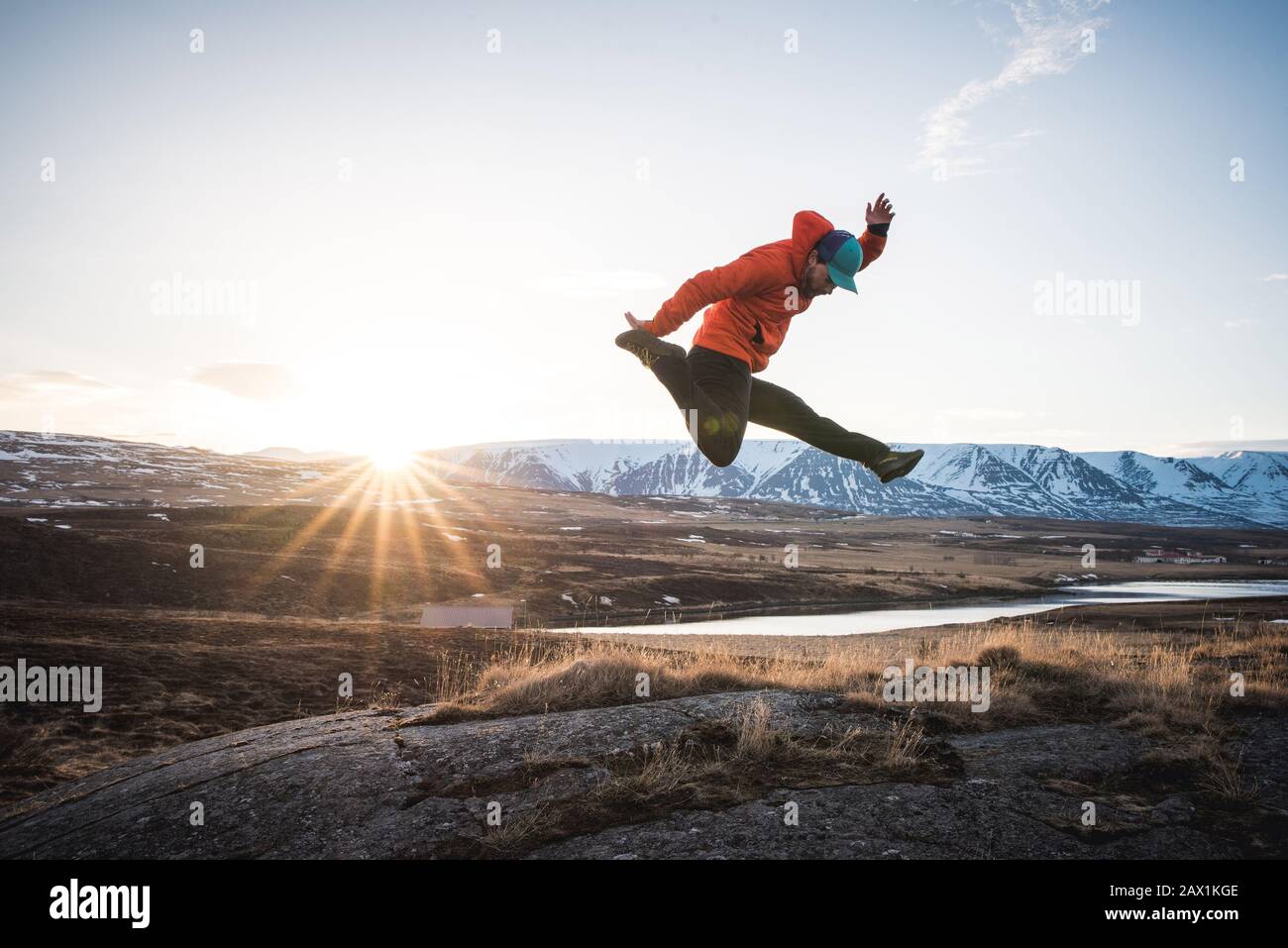 Man jumping with mountains and sun in background Stock Photo - Alamy