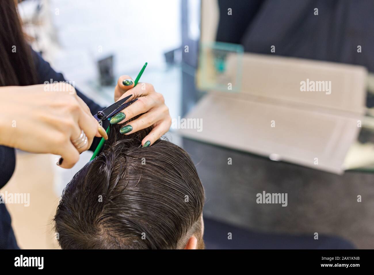 Female hairdresser hands doing haircut for male client using ...