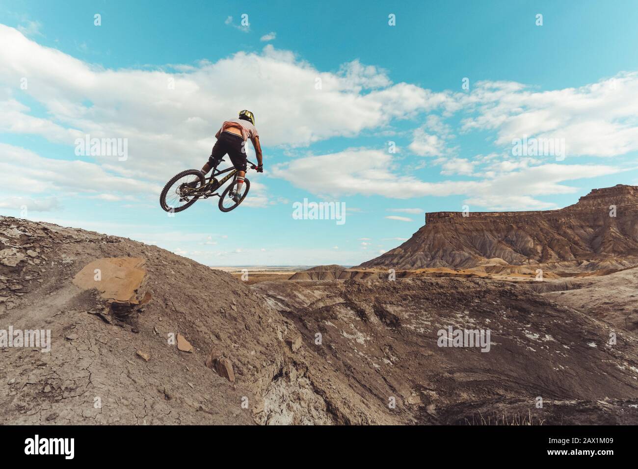 Male jumping with mountain bike in front of dramatic mountains Stock ...