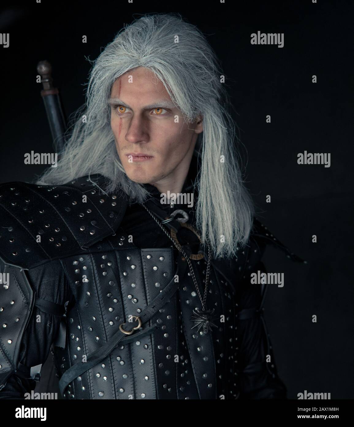 Portrait of man in image of ancient warrior witcher with sword behind ...