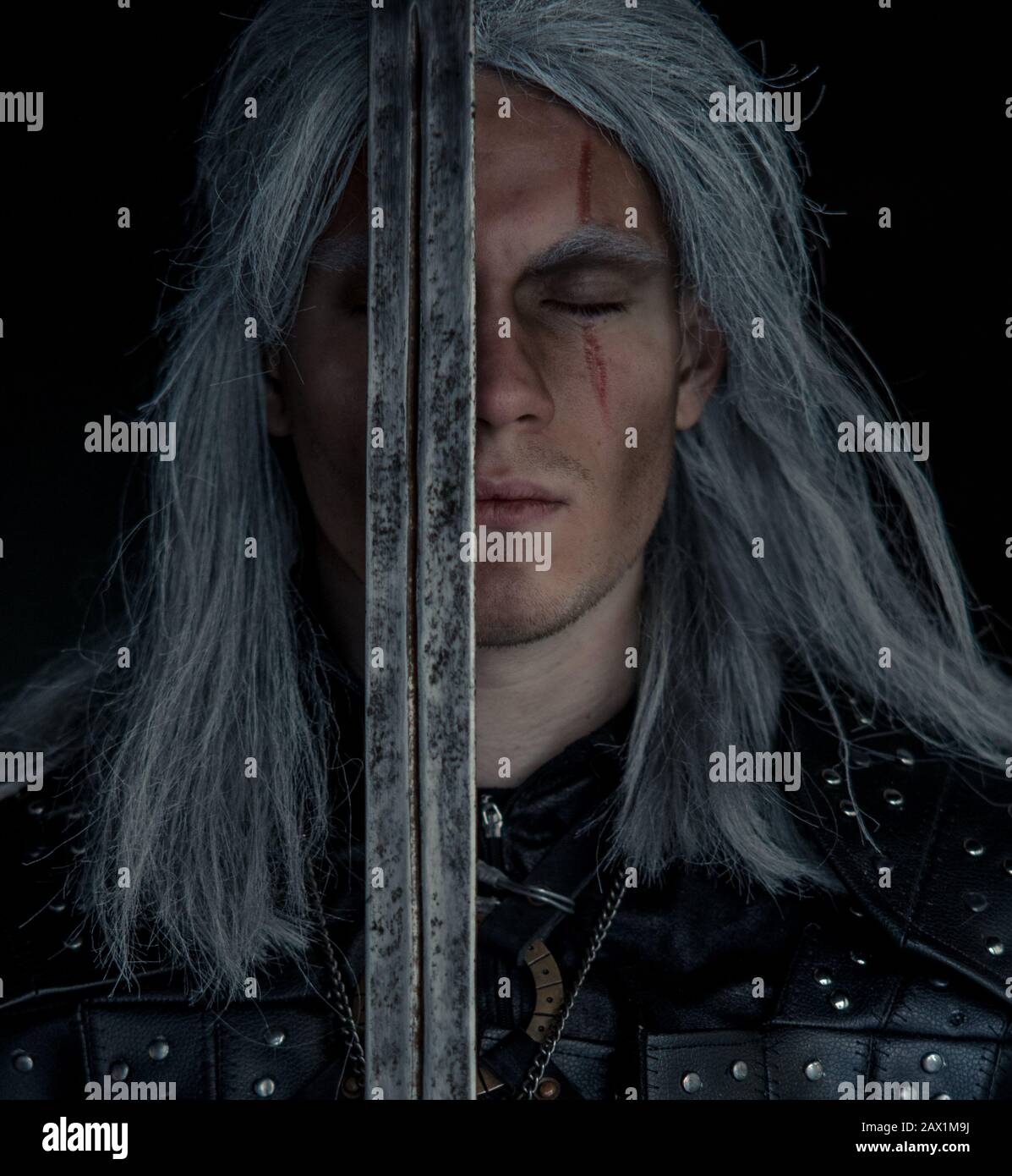 Portrait of man in image of ancient warrior witcher with sword in his ...