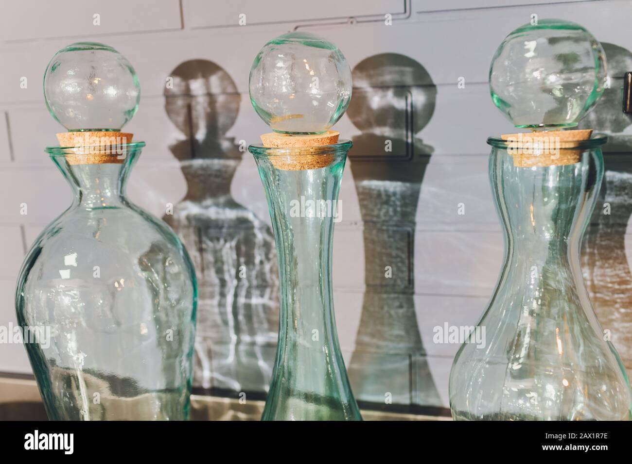 Three empty glass bottles standing in a row Stock Photo - Alamy