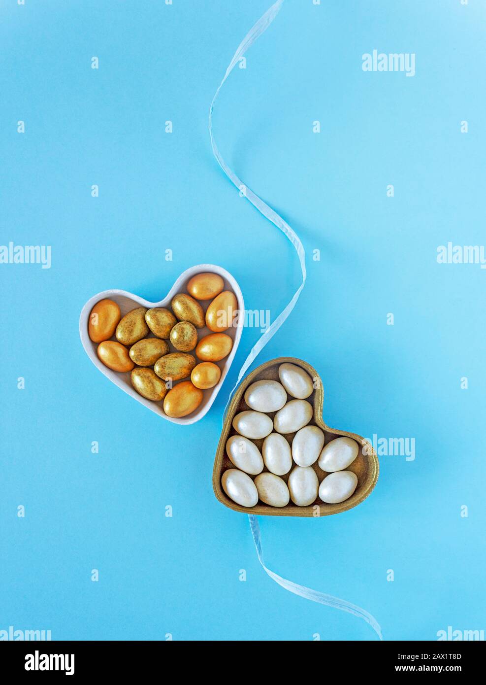 Concept of food designed for Valentine's day. Almonds in white, gold ...