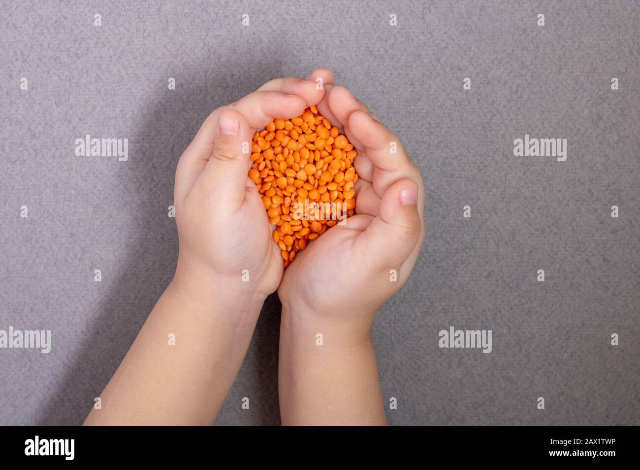 Kids hands holding red Lentils, top view food and place for text Stock ...