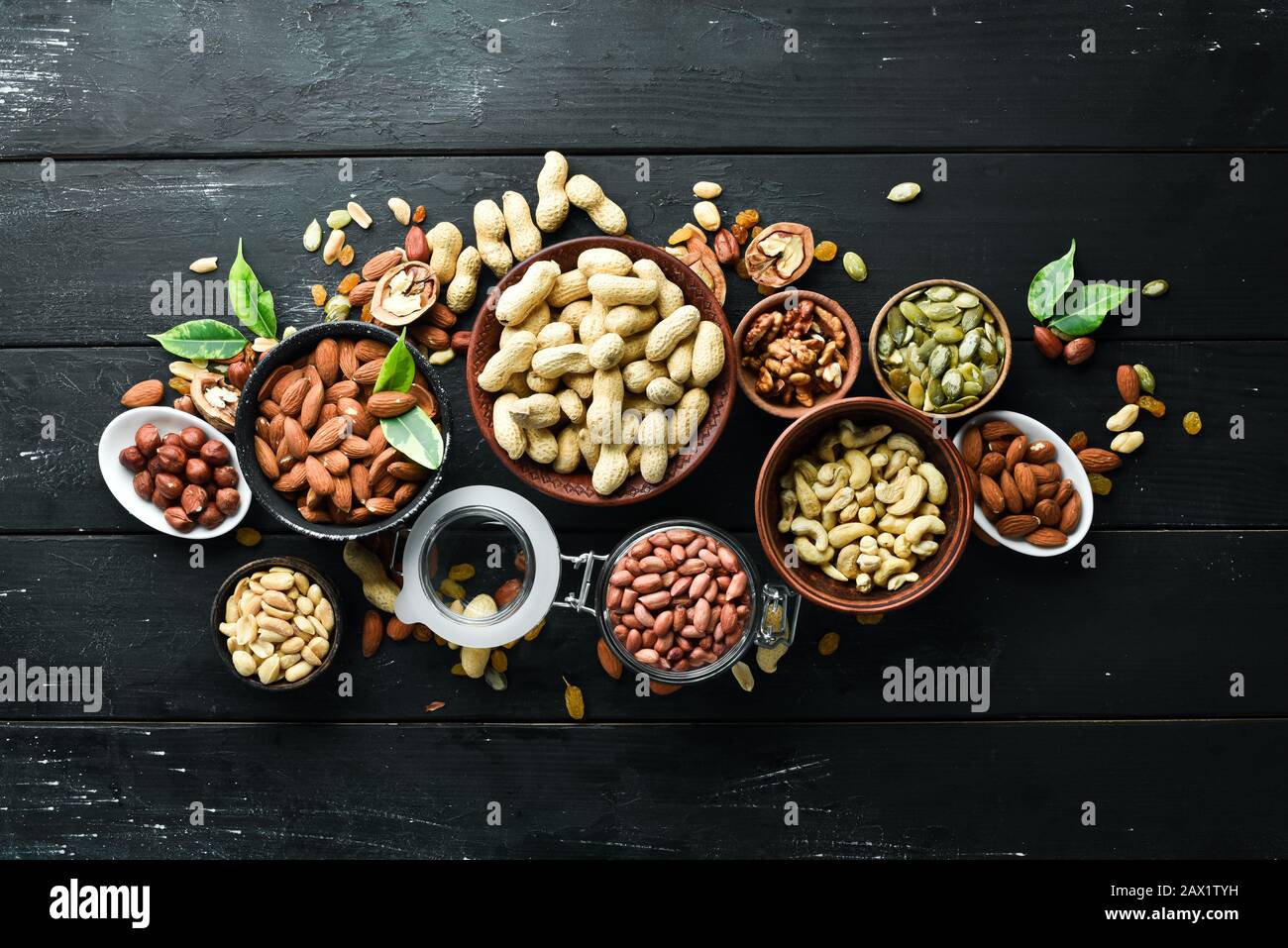 Assorted nuts on the old black background. Top view. Free space for ...