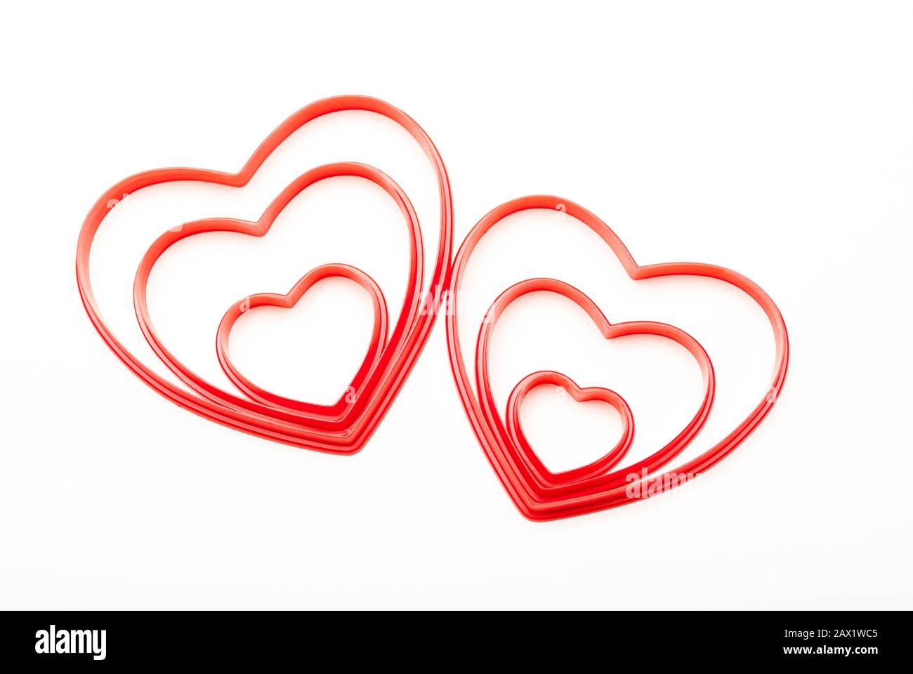 Pair of concentric red heart shapes nestled together on a white ...