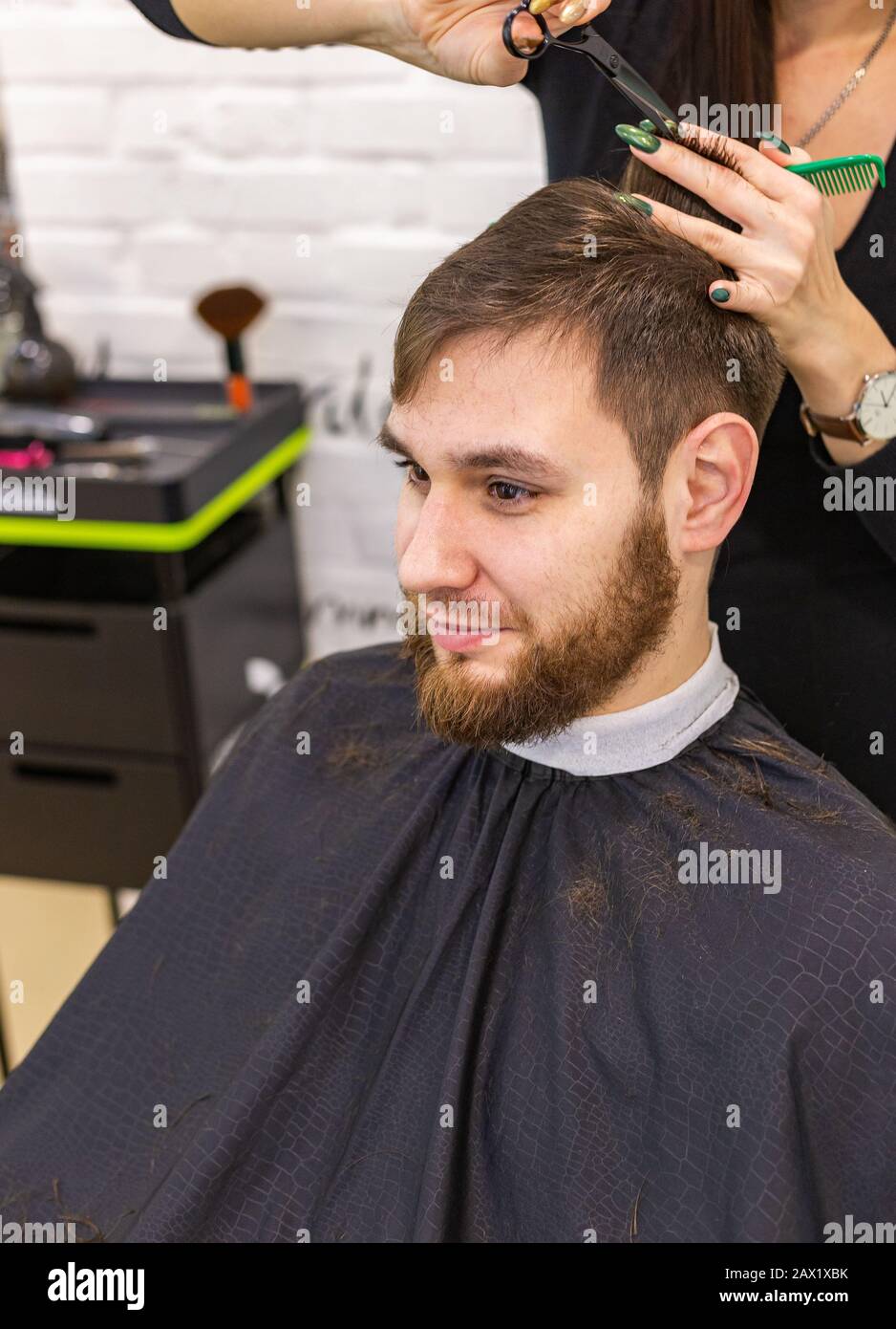 Hairdresser doing haircut for male client, man with beard using ...