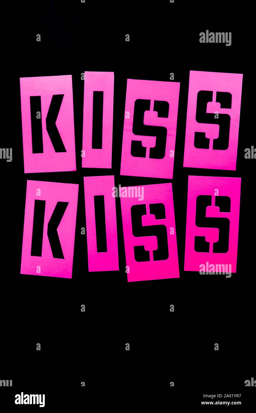 Pink stencil letters spell out Kiss Kiss on black background Stock ...