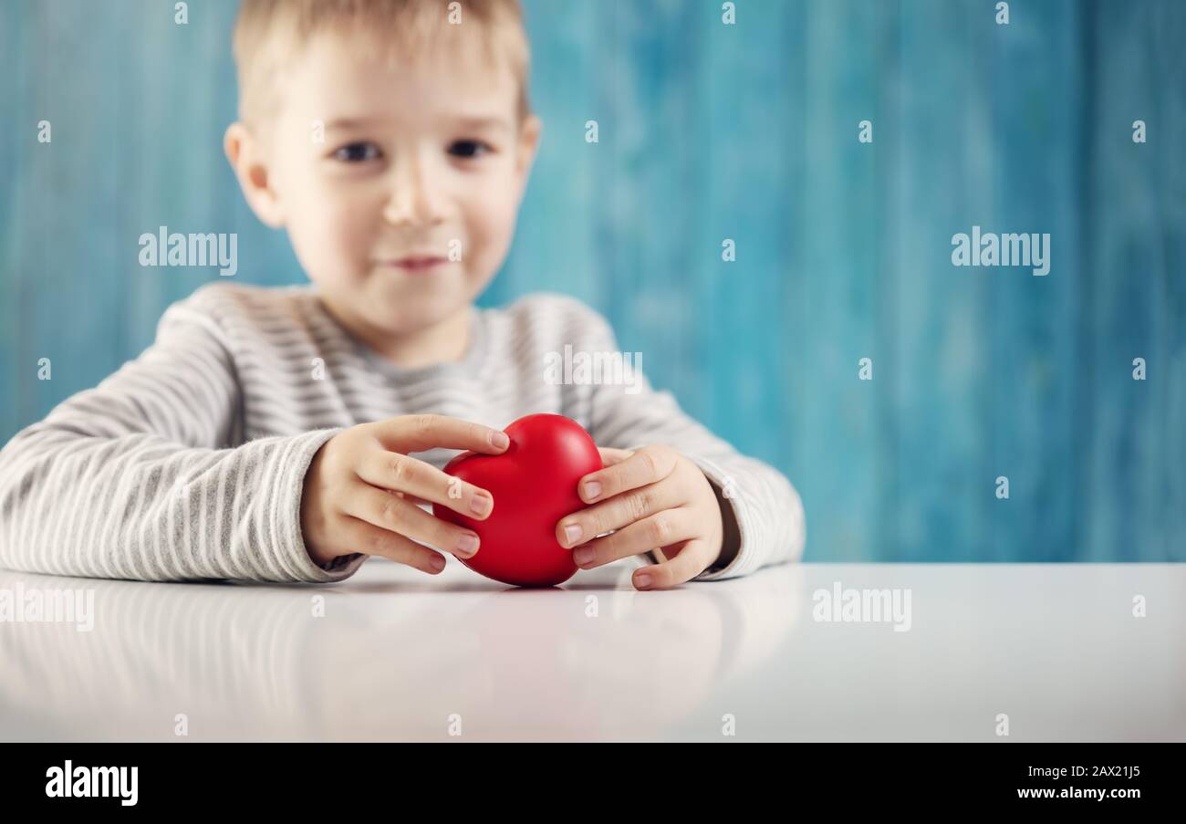 Cute little child holding red heart in hands Stock Photo - Alamy