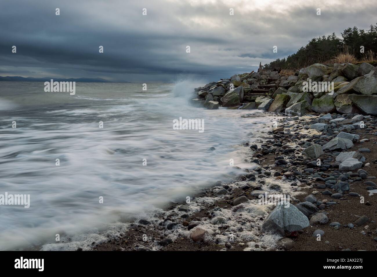 Stormy morning along a rocky beach with dramatic waves hitting rocks ...