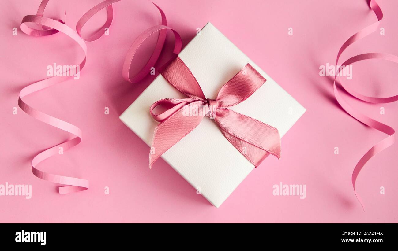 White gift box with pink ribbon on the pink background Stock Photo - Alamy