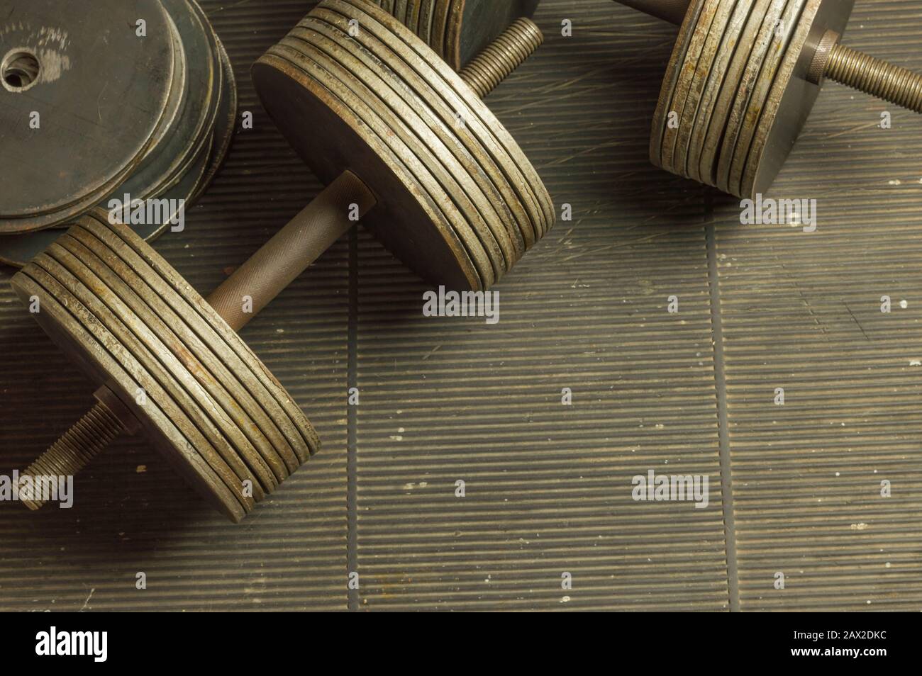 Old Iron Rusty Dumbbells and Additional Plates on scratched rubber ...