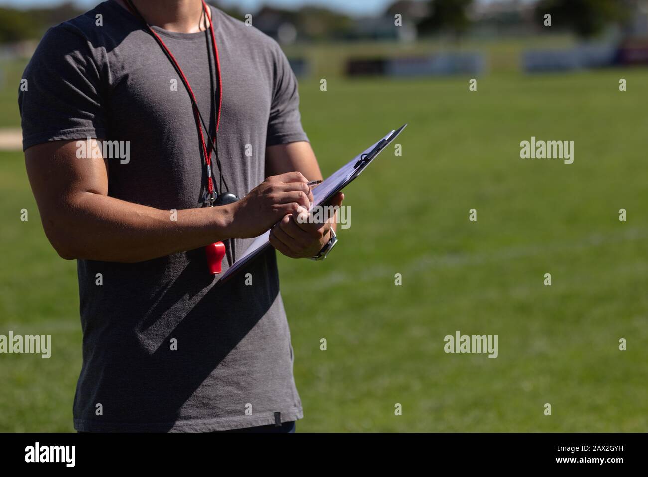 Rugby coach writing notes Stock Photo - Alamy