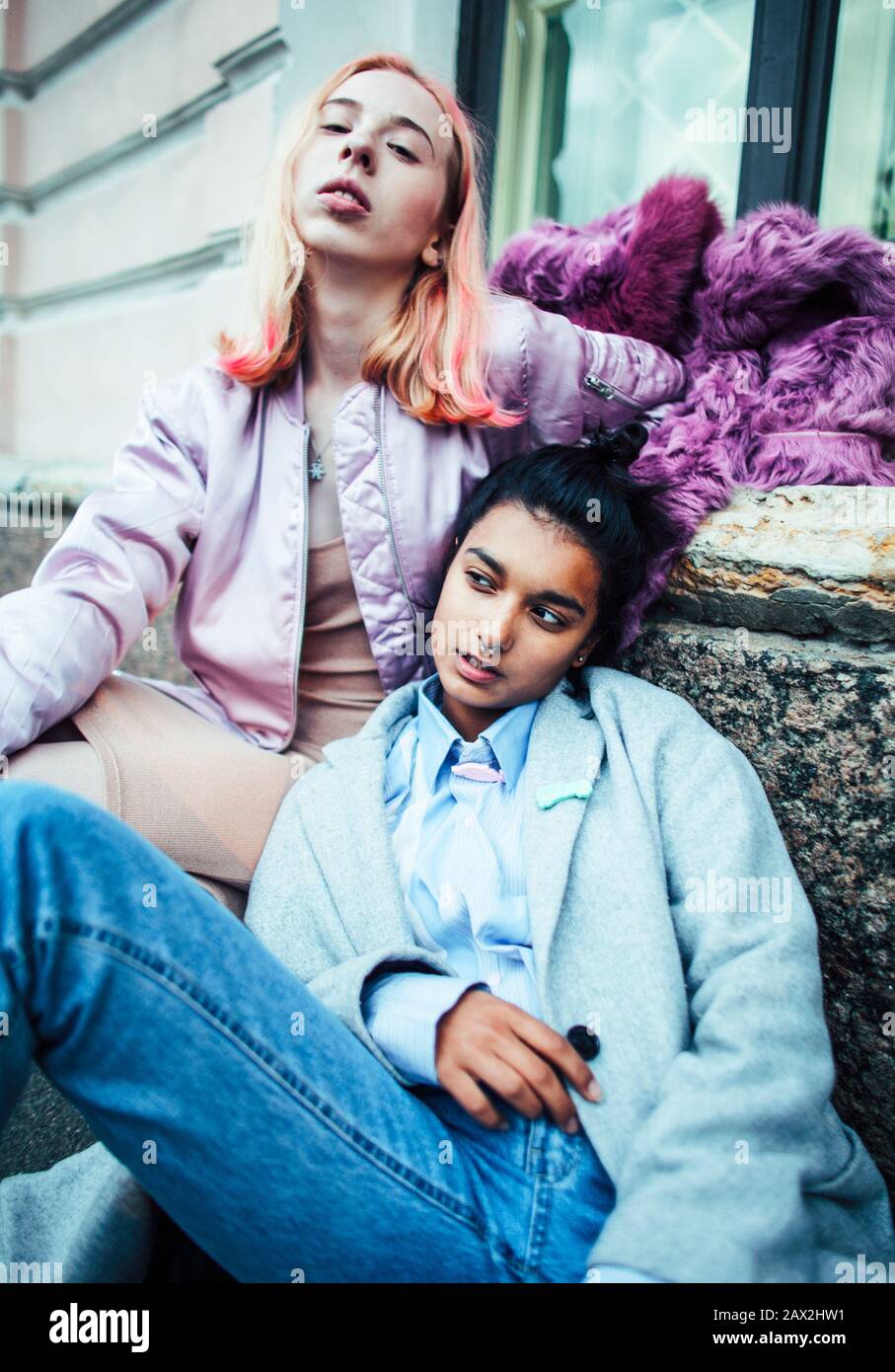 Two teenage girls infront of university building smiling, having fun ...