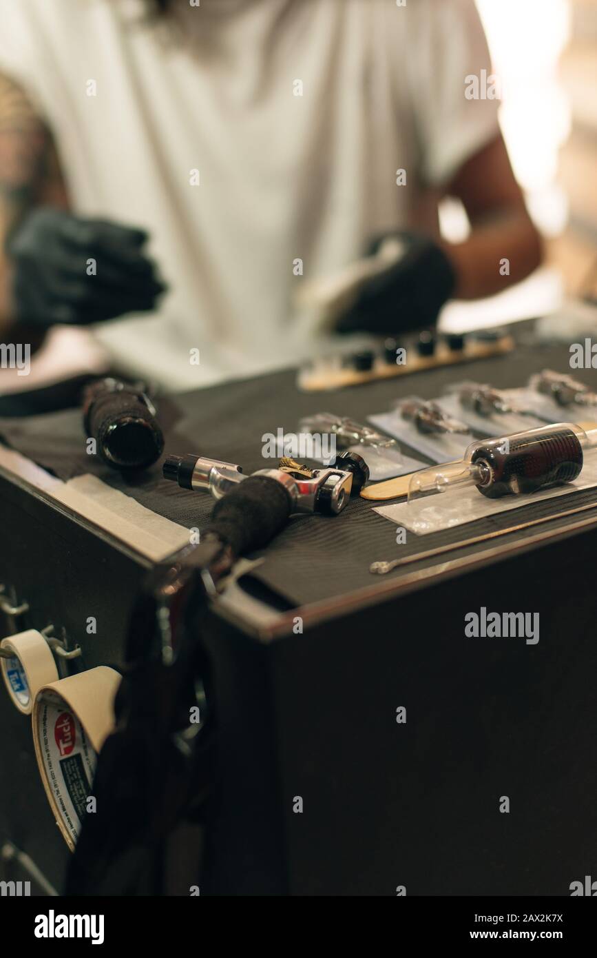 Tattoo artist workplace with machine and bottles with black tattoo ink ...