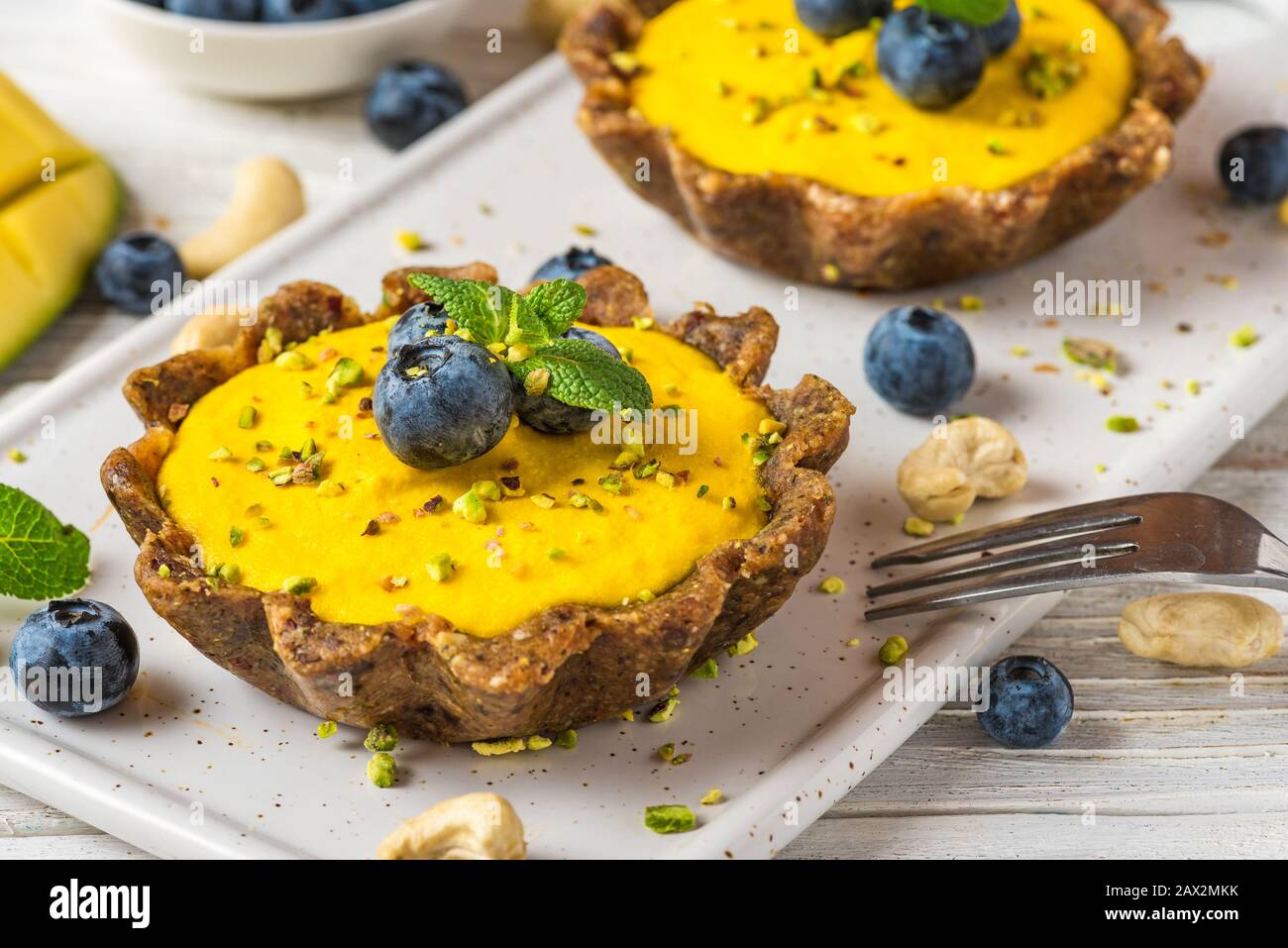 yellow mango vegan raw cakes with blueberries, mint and nuts. healthy ...