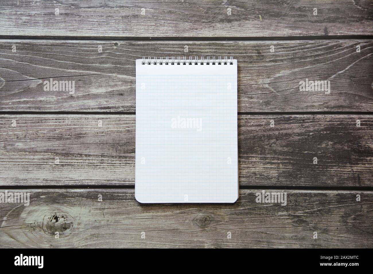 Notepad with a blank white sheet in a checker paper lies on the ...
