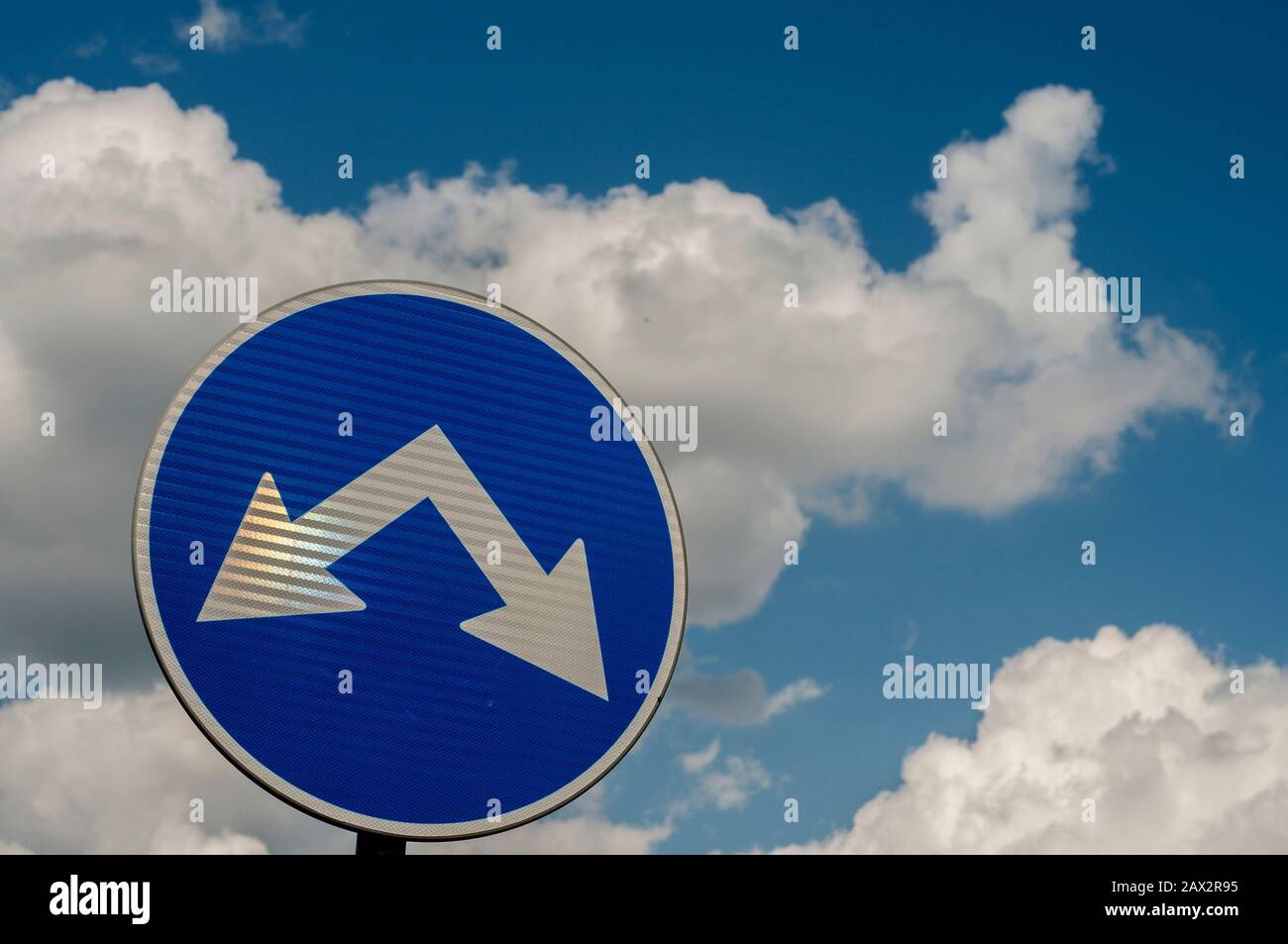 Blue traffic road sign with two arrows for two directions closeup on ...