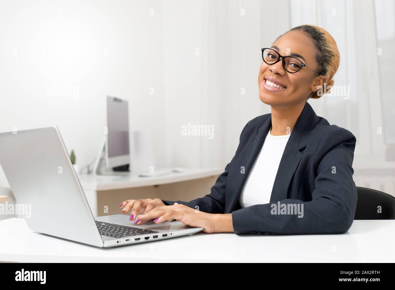Business African American young woman working in office at laptop ...