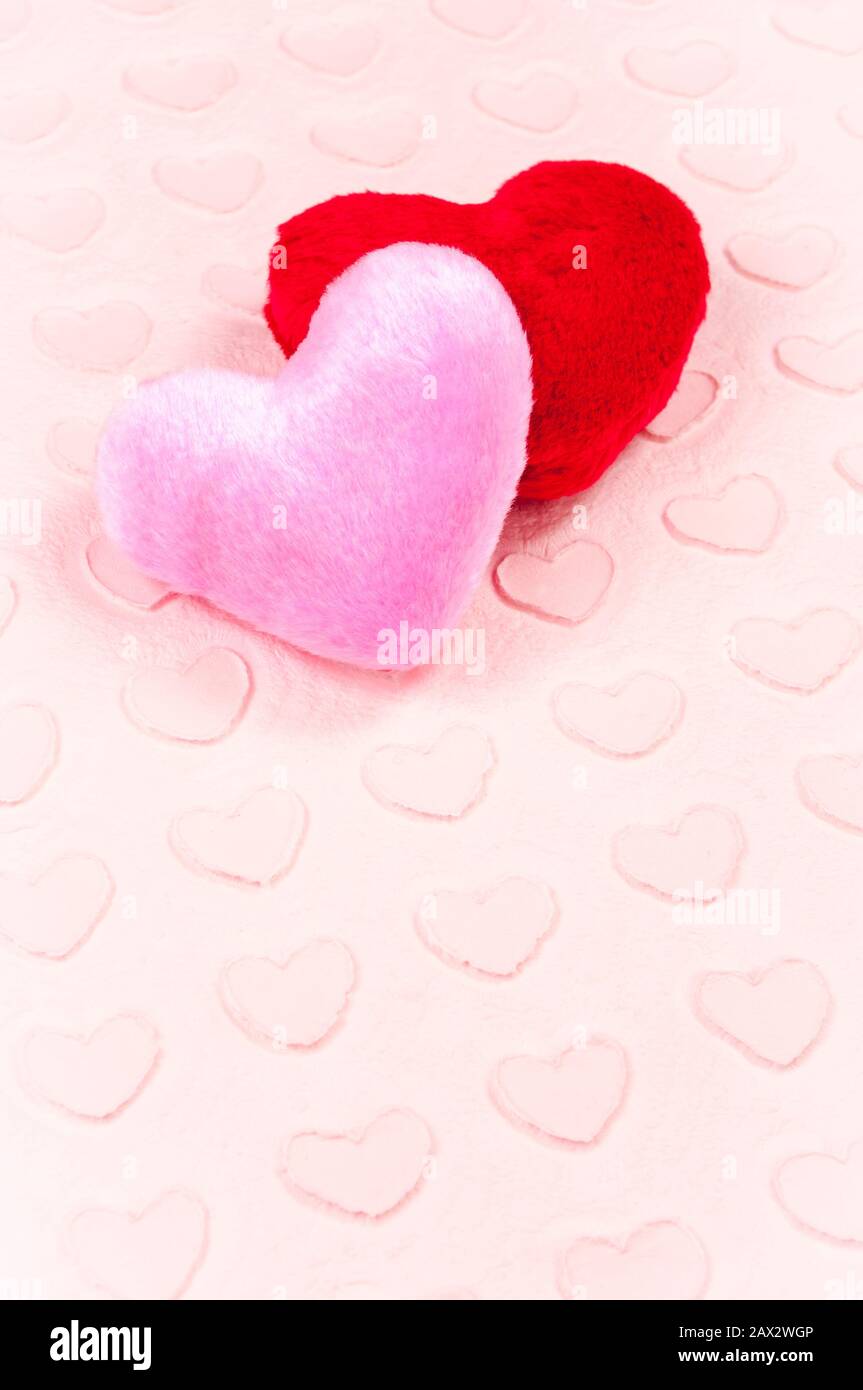 Pink and red fuzzy hearts snuggling together on a soft pink heart ...