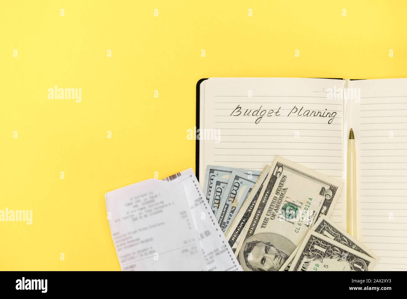 Expenses and budget planning. Above view of dollar banknotes, pen ...