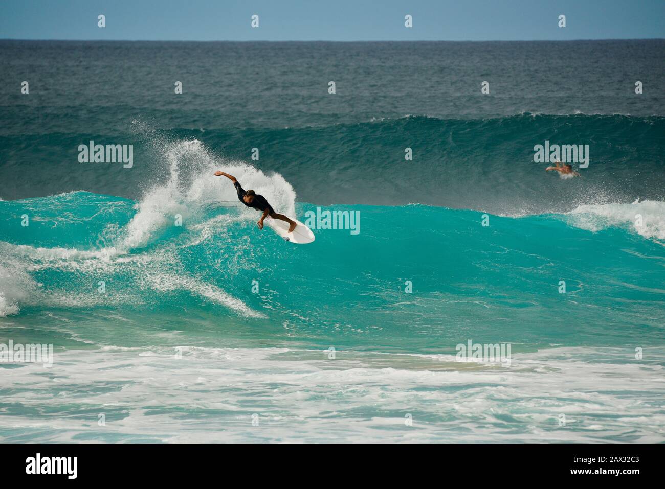 Male surfer riding world-renowned crashing, barreling curved turquoise ...