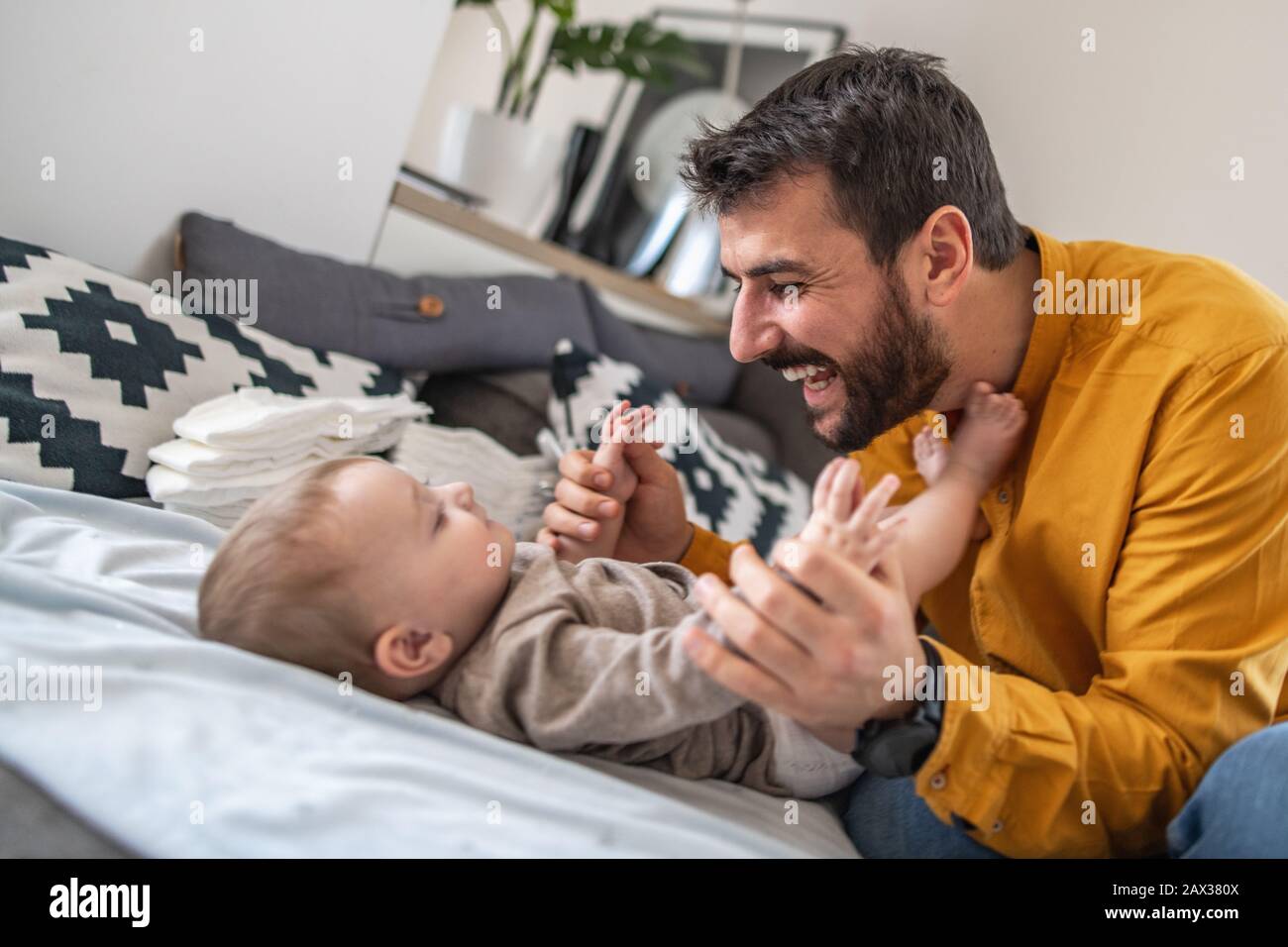 Father and baby.Young dad is changing baby diaper.Happiness and harmony ...