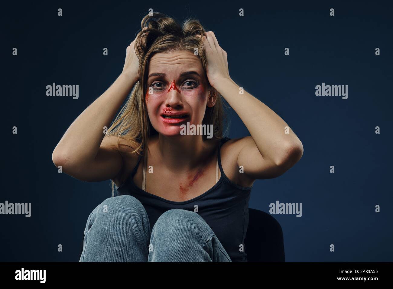 Scared blonde female, bleeding face covered with bruises, in black ...