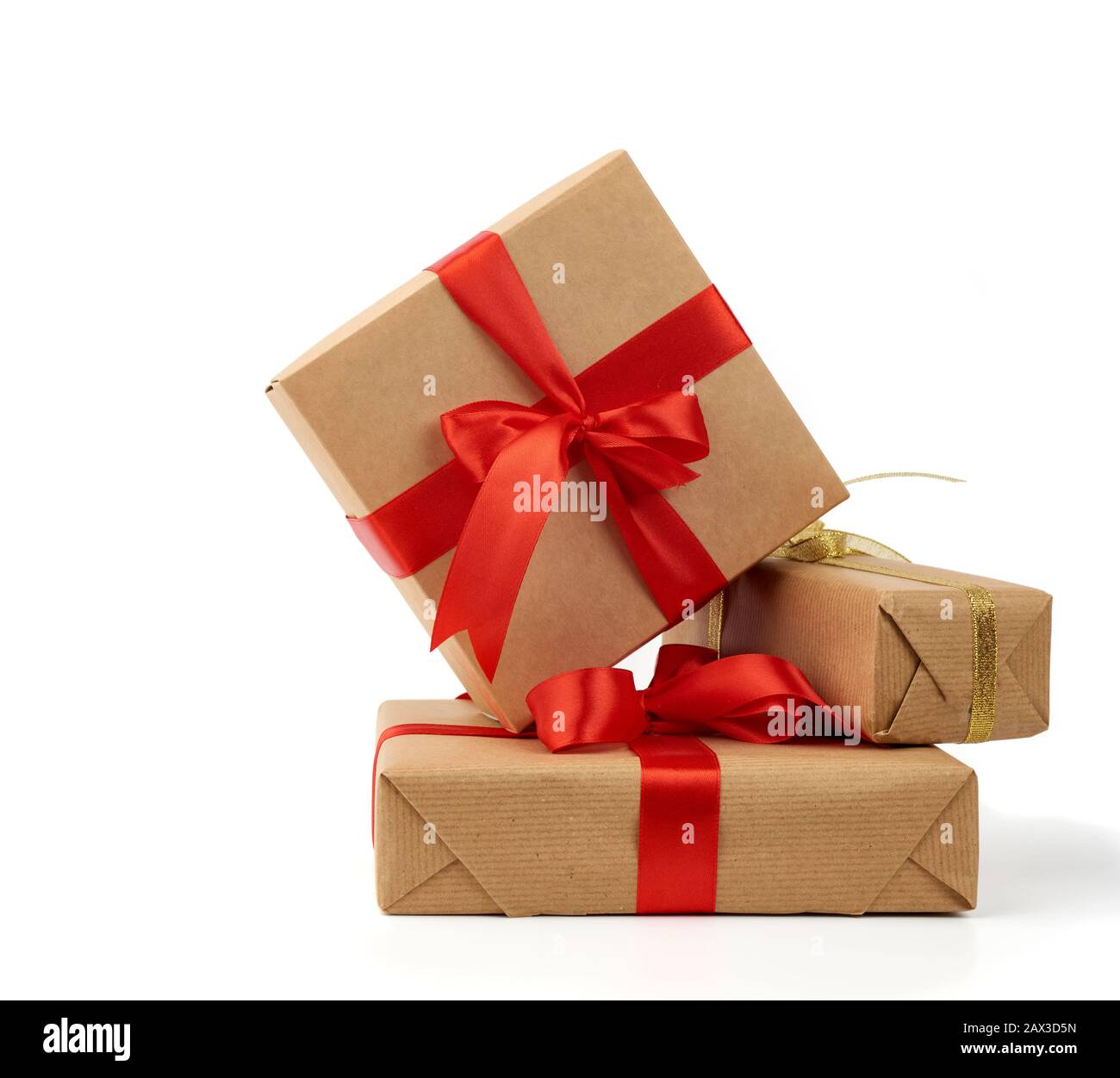 stack of gifts wrapped in brown kraft paper and tied with silk golden ...