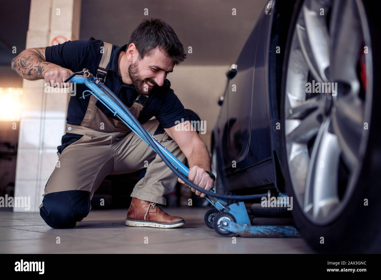 Professional auto mechanic changing a tire in auto repair shop.Man ...
