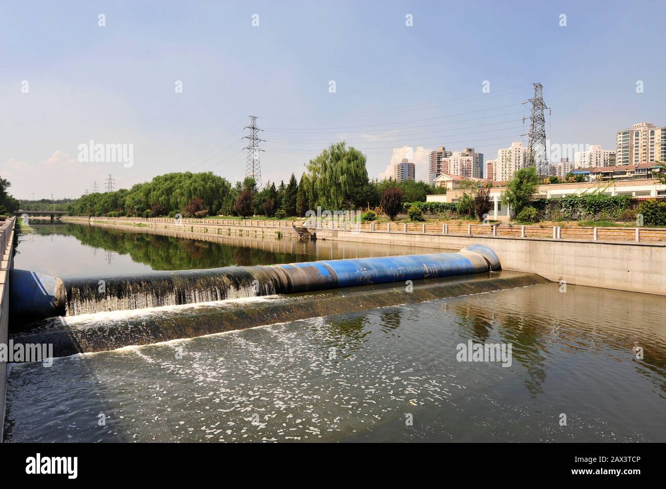 Channelised river with small blue dam in northeastern Beijing, China ...