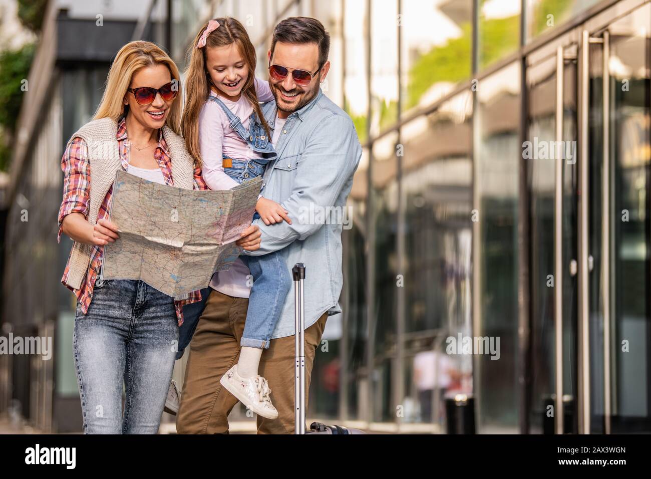Happy family of tourists looking for destination with city map.People ...