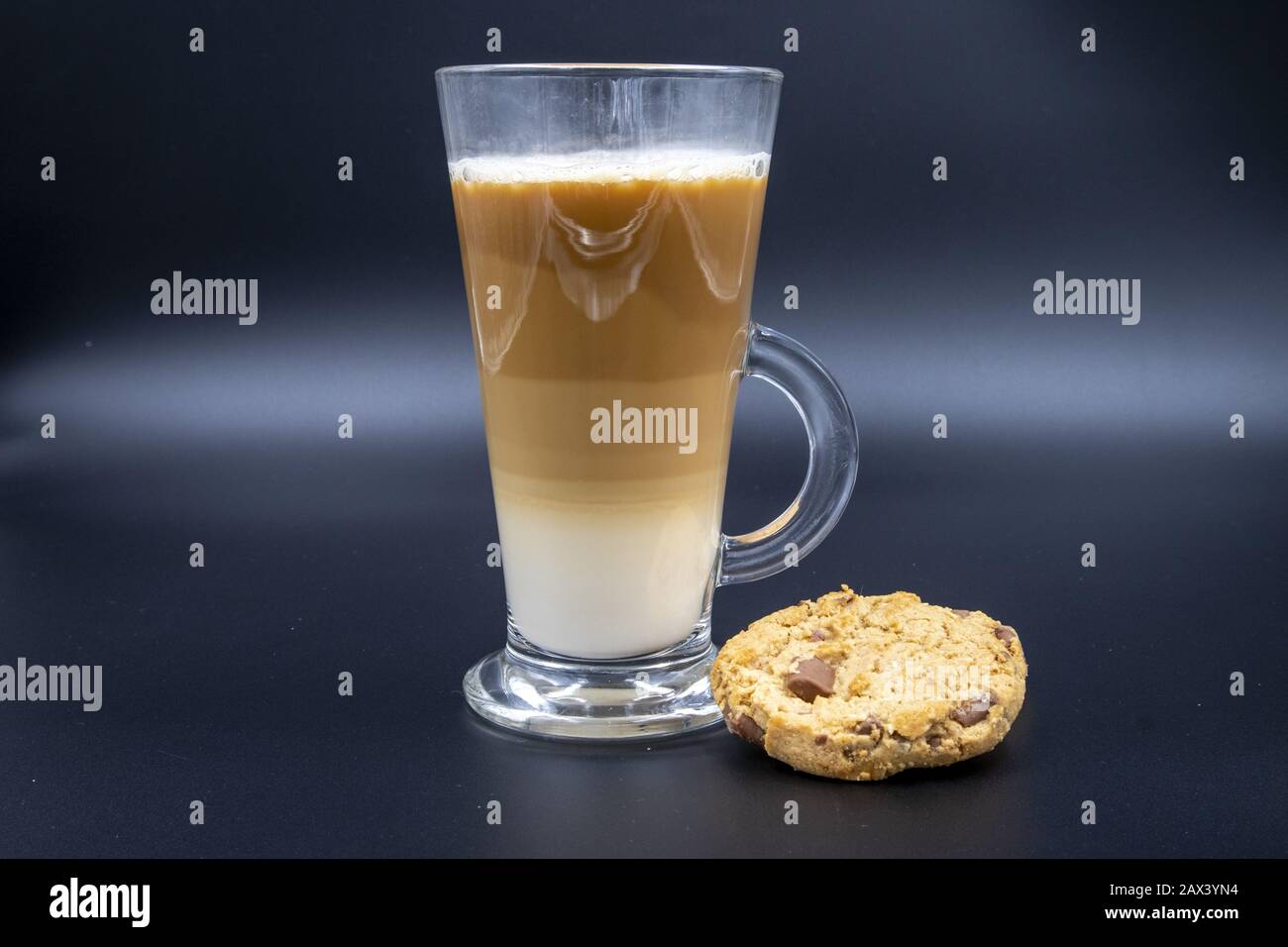 Studio shot of three layered tea drink with a chocolate chip cookie in ...