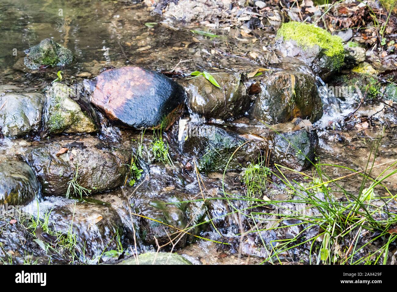 Closeup shot of a cascade of water over mossy stones Stock Photo - Alamy