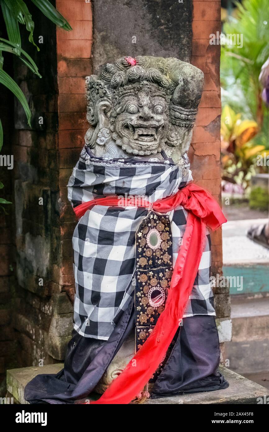 A stone statue of a Hindu demon or god dressed in the traditional saput ...