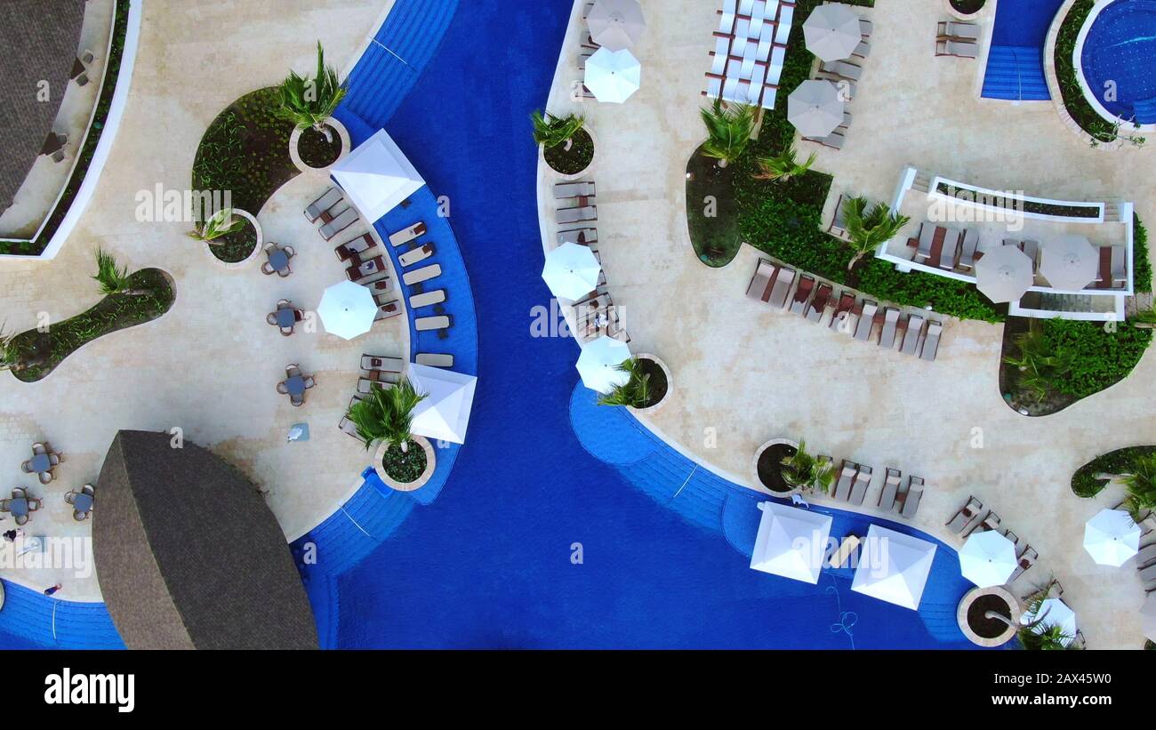 Modern pool area in holiday resort, aerial top down view, relaxation ...