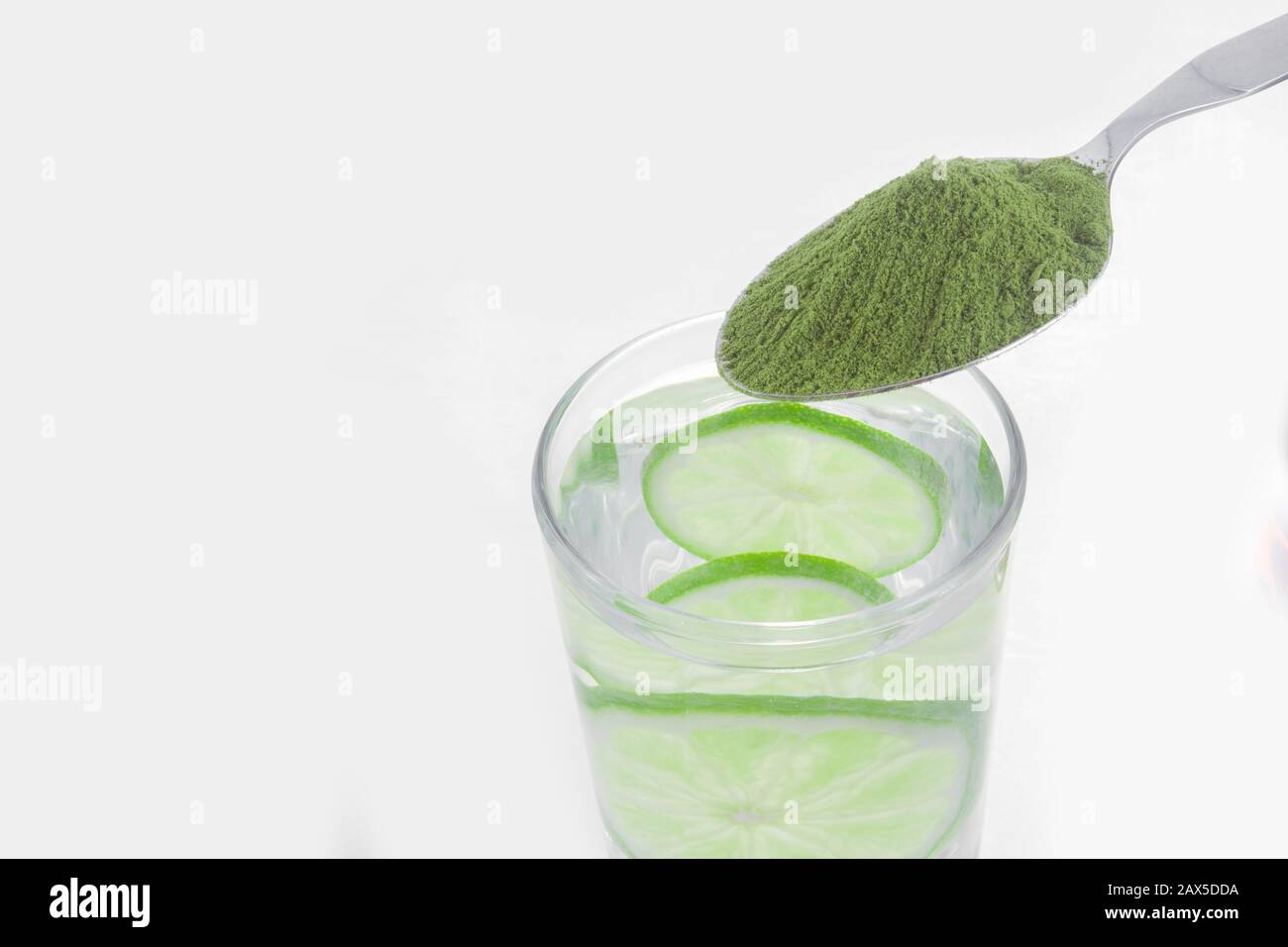 Moringa powder with lemon and glass with water isolated on white ...