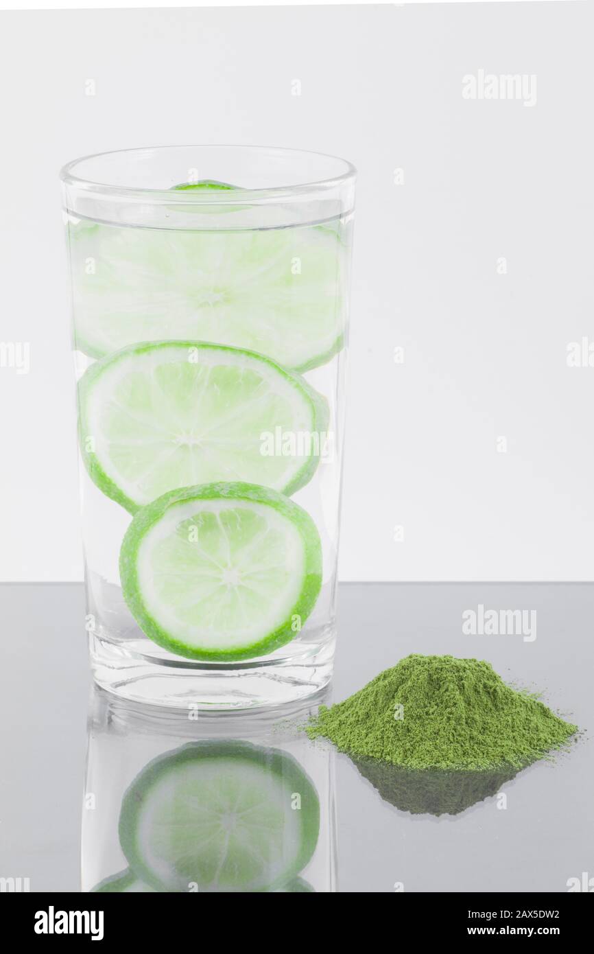 Moringa powder with lemon and glass with water isolated on white ...