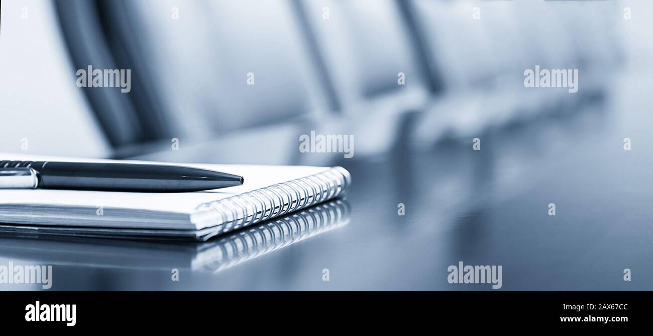 Closeup of notepad kept on table in empty conference room Stock Photo ...