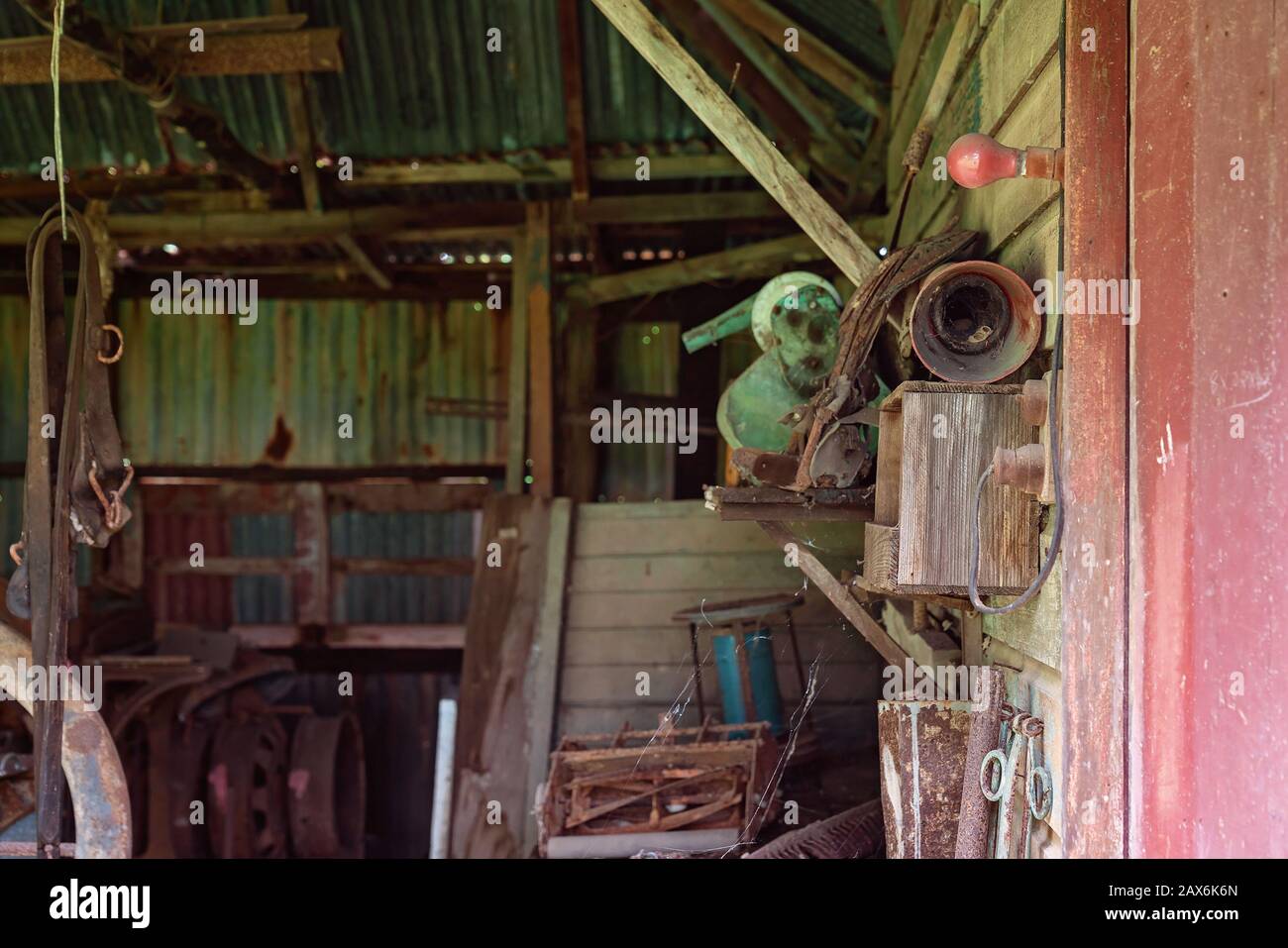 Old rusted farm tools from yesteryear in an abandoned country shed ...