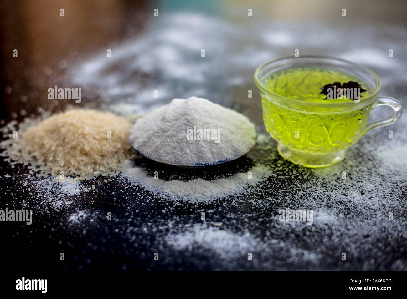 Rice flour and rice grain on wooden surface along with some green tea ...