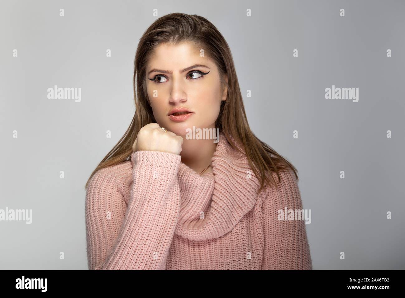 Close up portrait of a young Caucasian woman wearing a pink sweater on ...