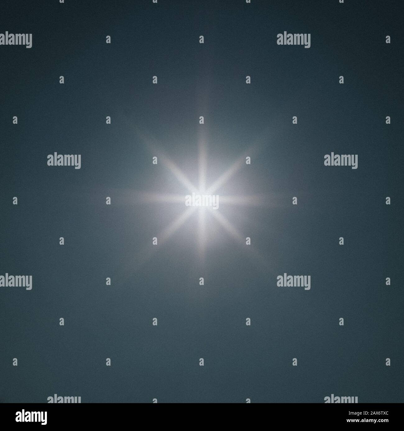 Vertical shot of a white lens flare on a bluish background Stock Photo ...