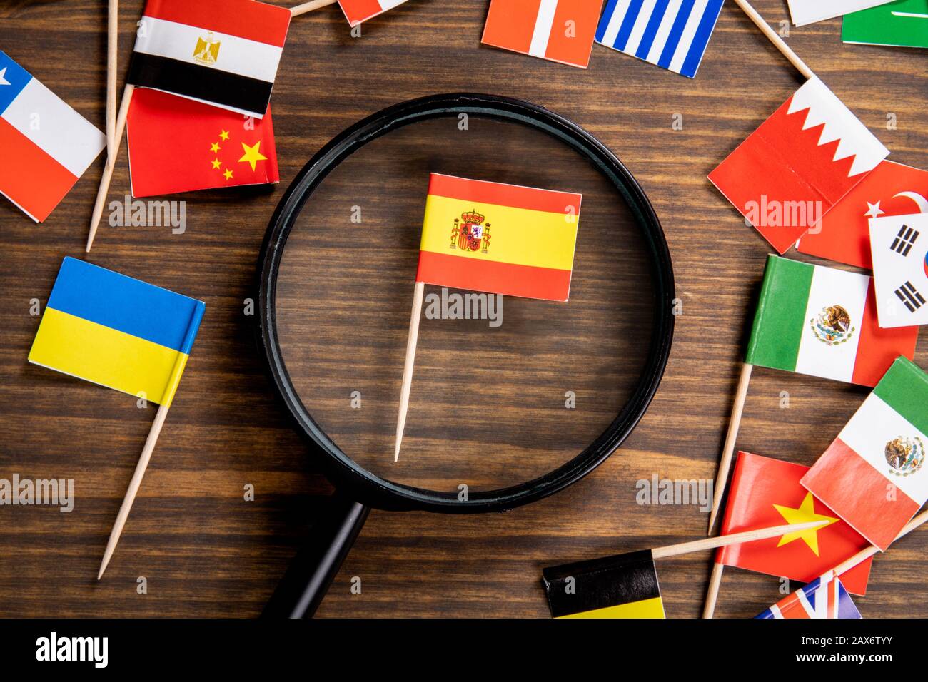 Spanish flag. Flags of many countries, magnifying glass on wooden table ...