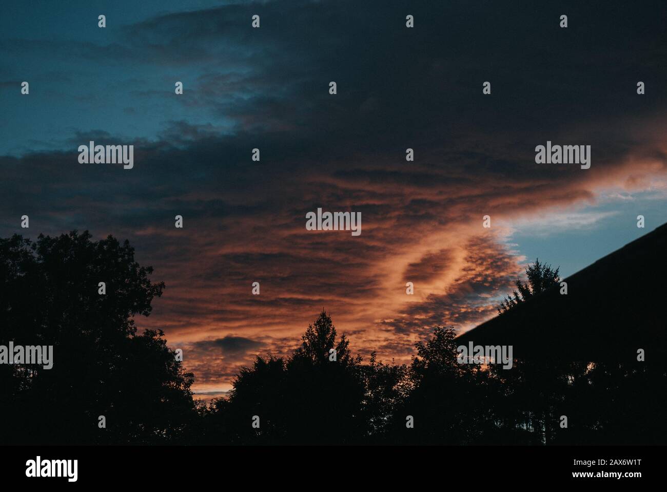 Beautiful dusk sky with silhouettes of trees and a roof Stock Photo - Alamy