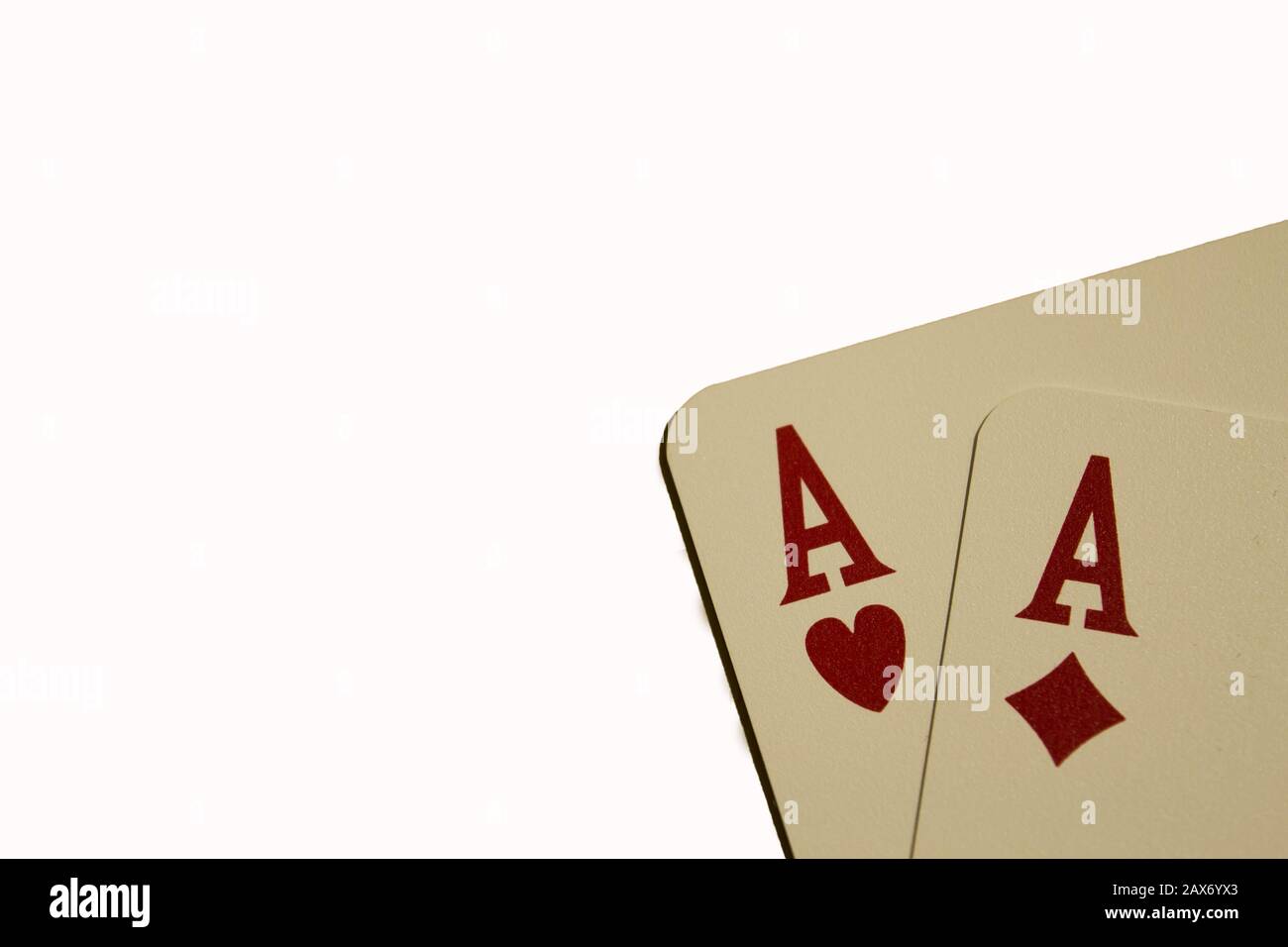 Closeup of two red ace cards under the lights against a white ...