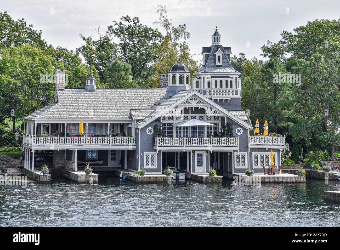 Big house on the river surrounded by greenery under the cloudy sky and ...